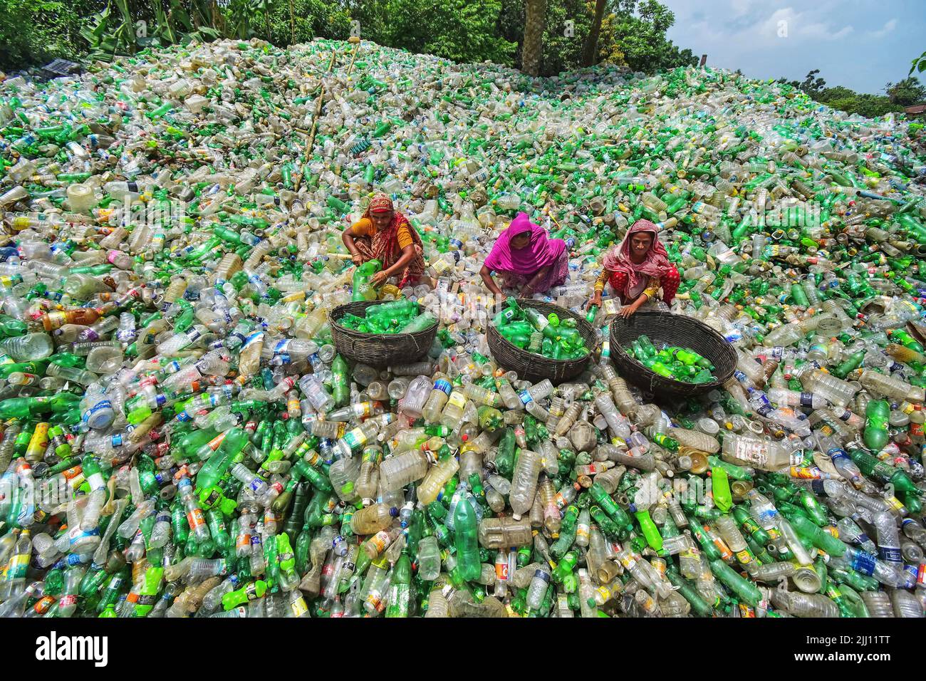 Workers sorting plastic bottles by hand in a recycling plant, Bogura ...