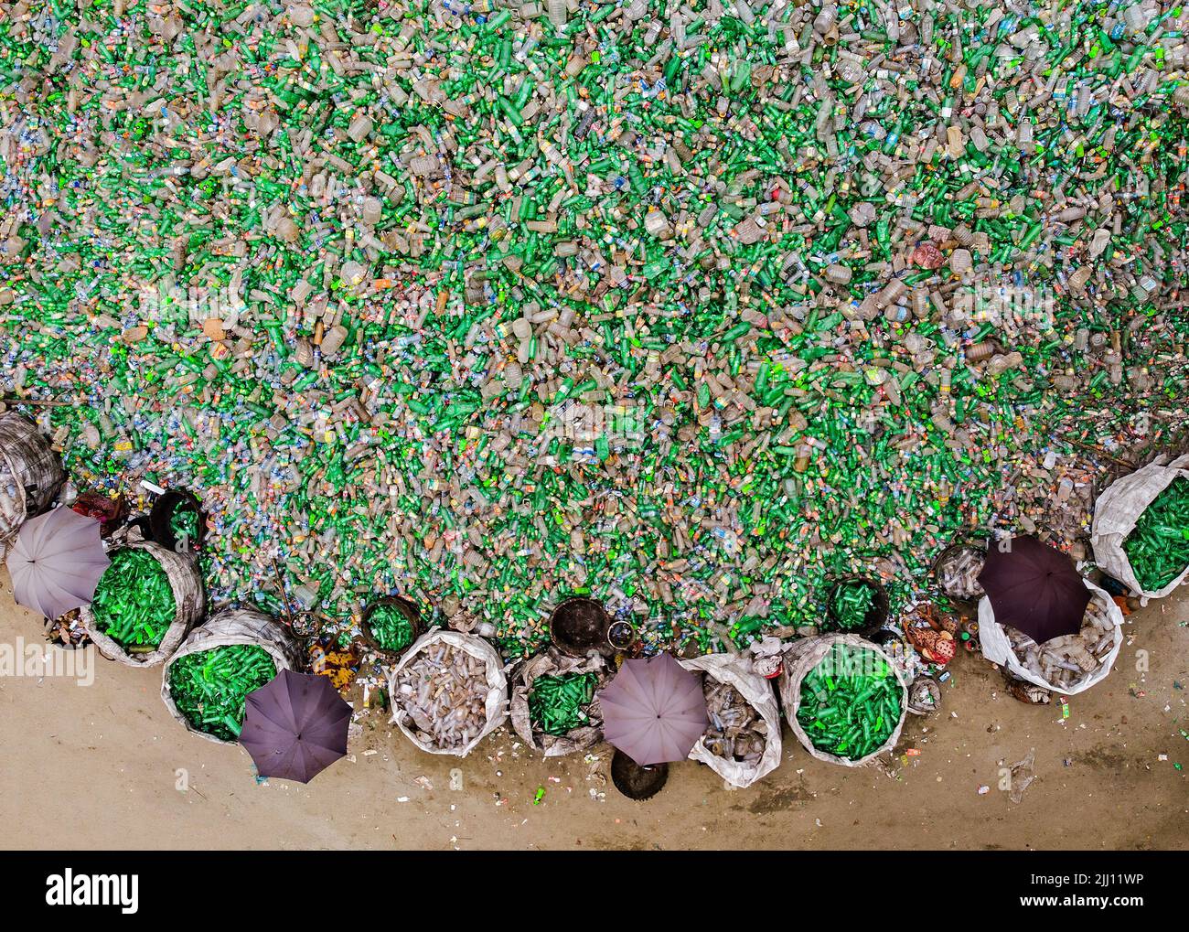Workers sorting plastic bottles by hand in a recycling plant, Bogura ...