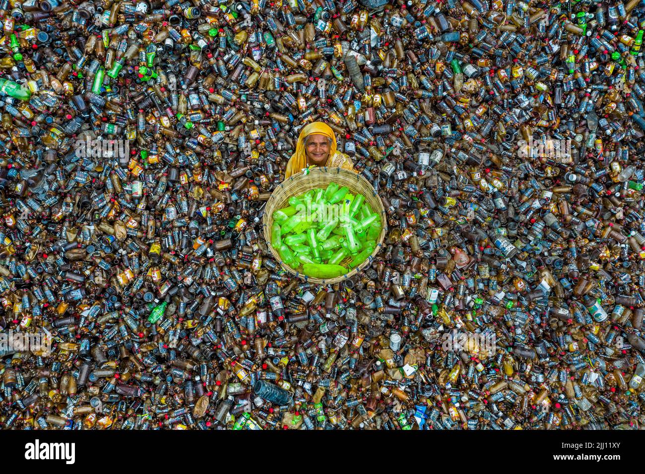 Workers sorting plastic bottles by hand in a recycling plant, Bogura ...