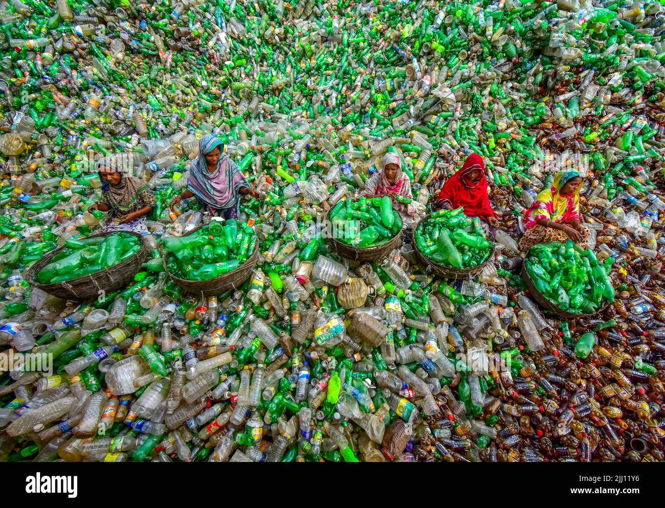 Workers sorting plastic bottles by hand in a recycling plant, Bogura ...