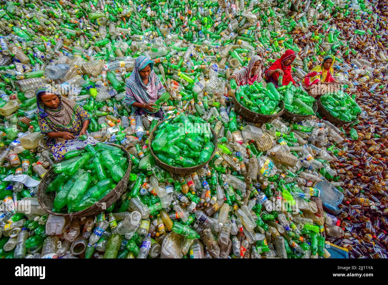Workers sorting plastic bottles by hand in a recycling plant, Bogura ...