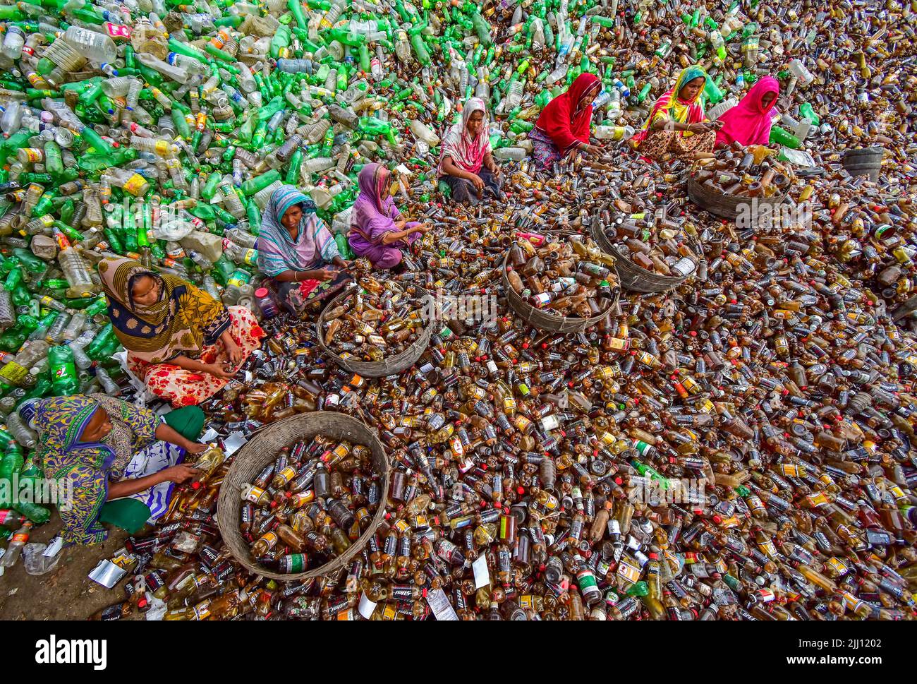 Workers sorting plastic bottles by hand in a recycling plant, Bogura ...