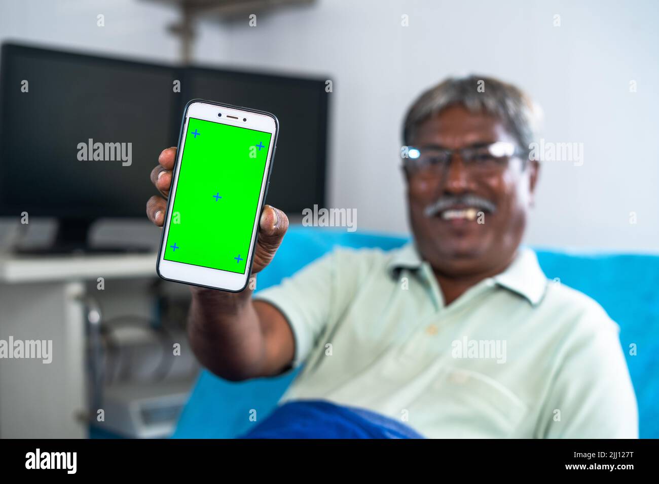 Focus on mobile phone Happy patient showing green screen mobile phone ...