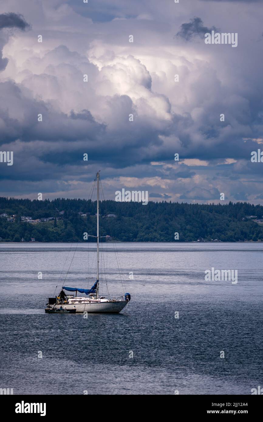 A boat cruising on a calm sea under a gloomy sky Stock Photo - Alamy