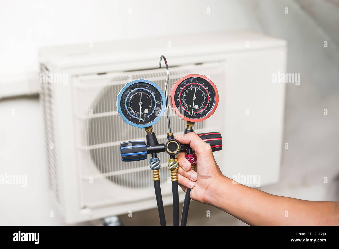 Air repair mechanic using measuring equipment for filling industrial ...