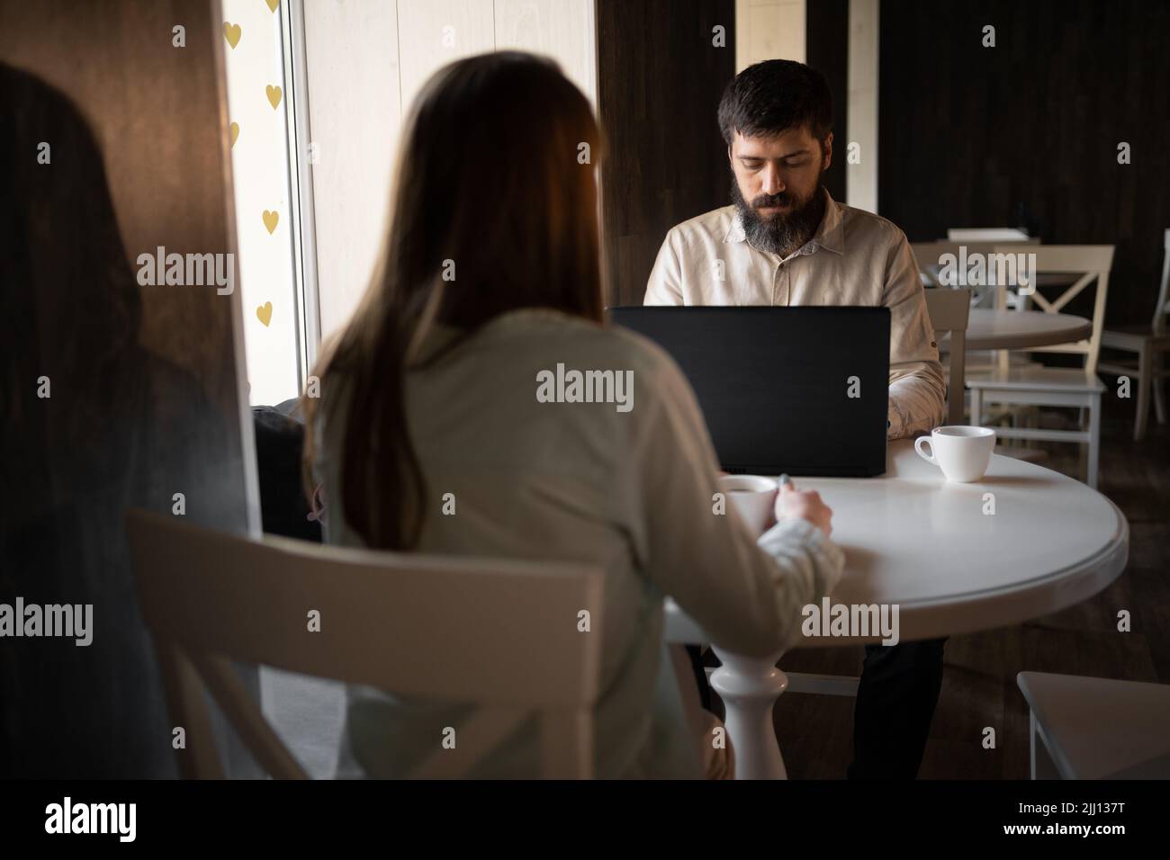 Young male graphic designer with laptop computer during collaboration ...