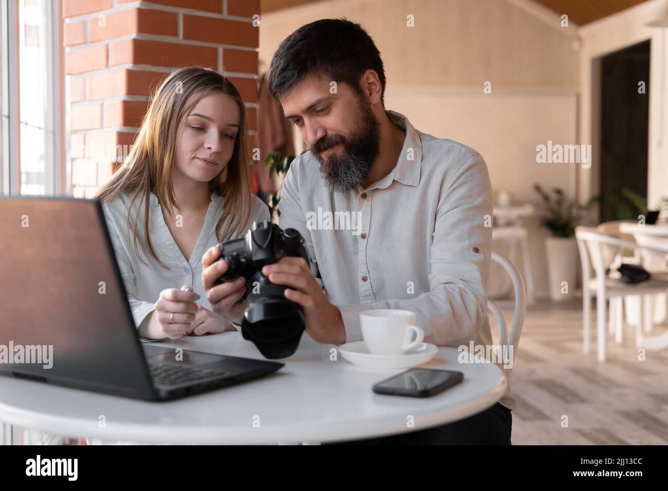 Young successful freelance photographer looking through pictures on ...