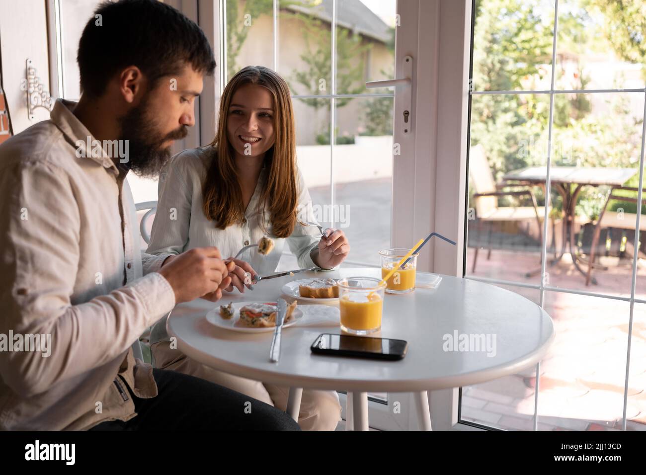 Beautiful couple having breakfast in a stylish cozy cafe, morning ...