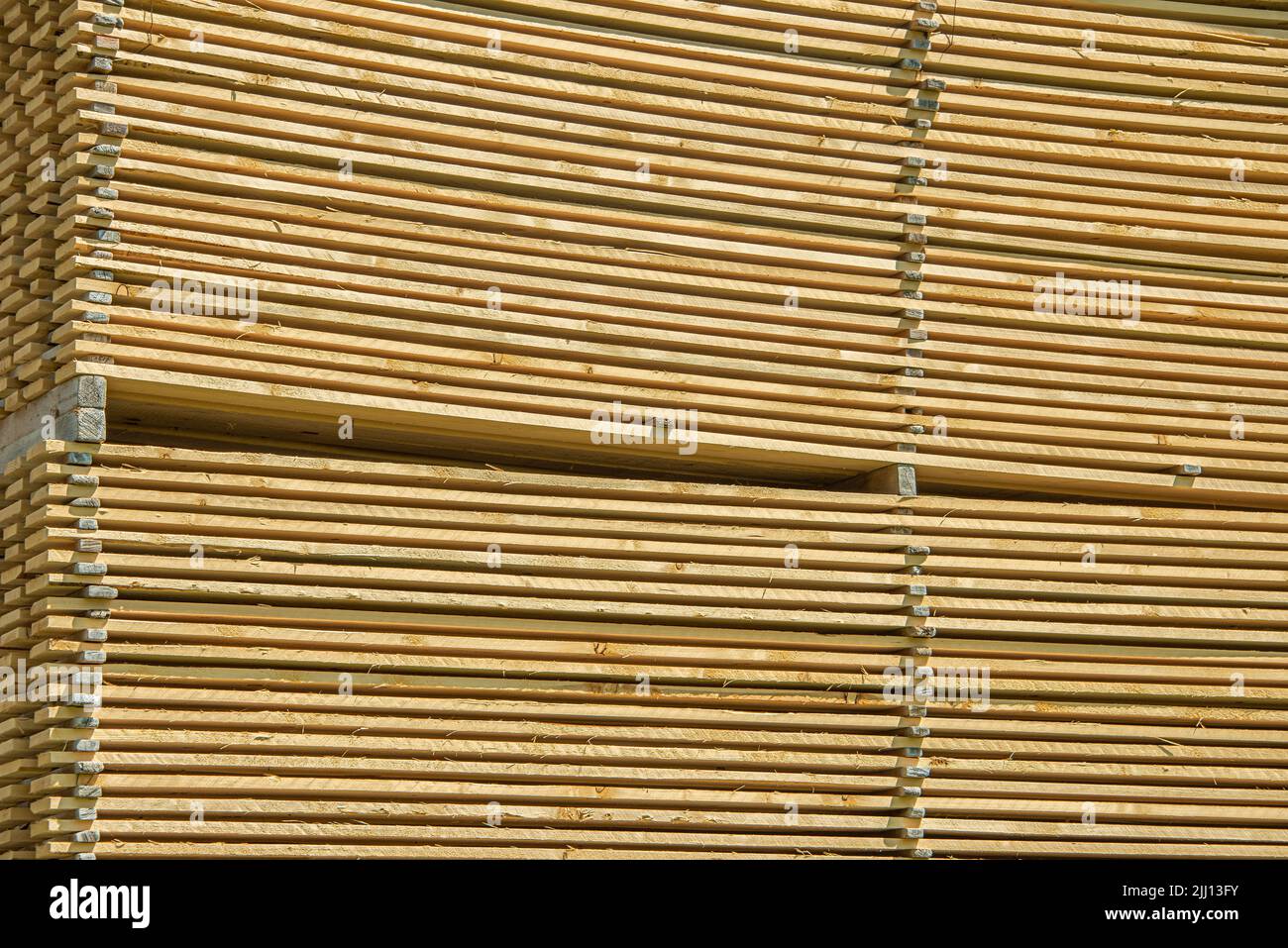 Lots of planks stacked on top of each other in the warehouse. Lumber ...