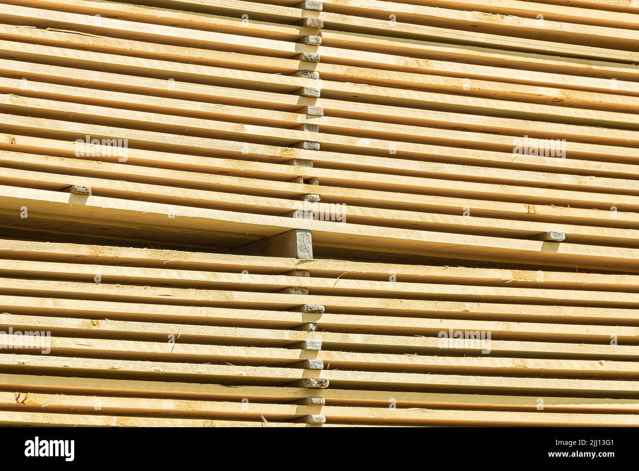 Lots of planks stacked on top of each other in the warehouse. Lumber ...