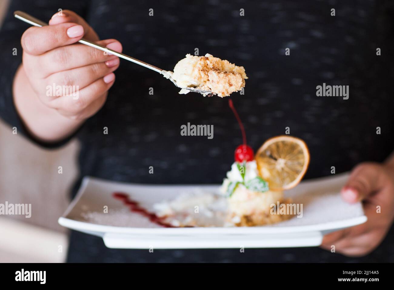 Customer eating sweet creamy orange dessert Stock Photo - Alamy