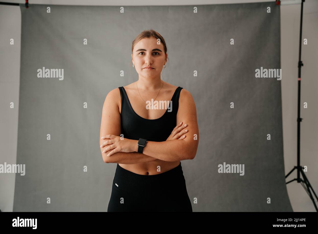 Seriously focused female standing crossed arms in a studio Stock Photo ...