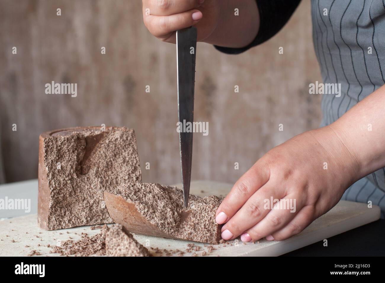 Cook breaks off piece of aerated chocolate Stock Photo - Alamy