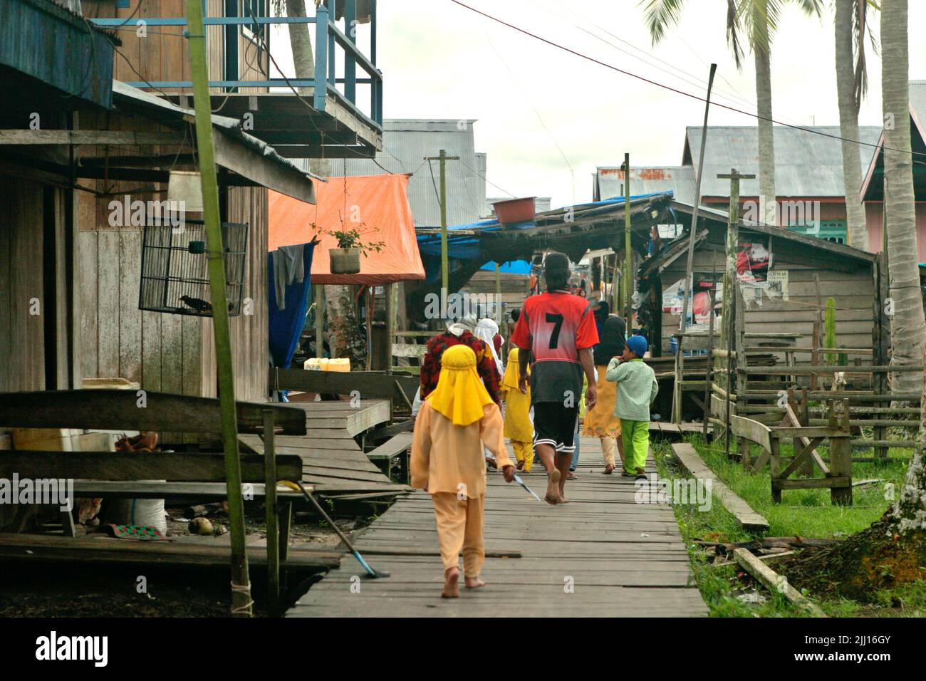 Villagers walking on a wooden walkway in Kasai, a coastal village where ...