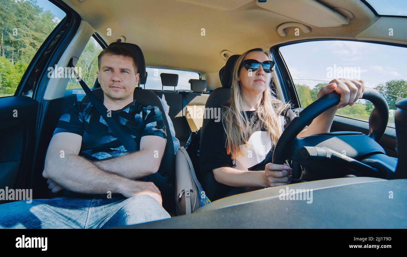 A man and a woman in a car are driving through town Stock Photo - Alamy
