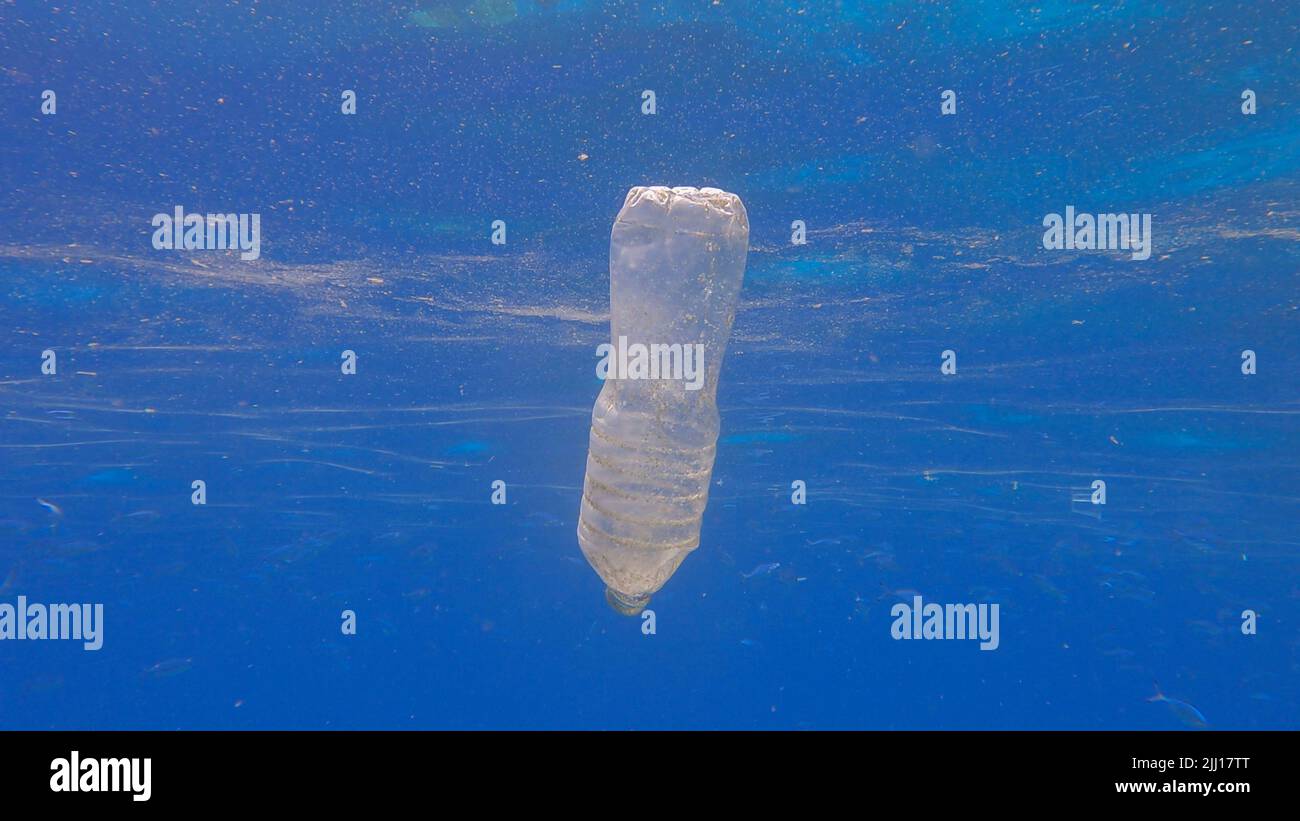 Plastic pollution, plastic bottle and cup in blue water. Discarded ...