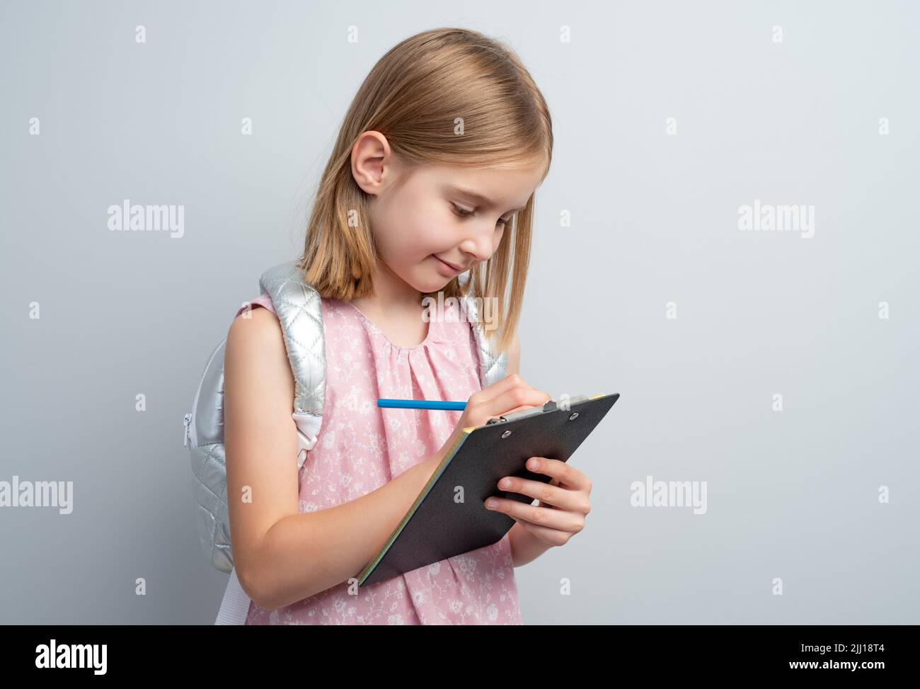 Little girl taking notes with pencil Stock Photo - Alamy