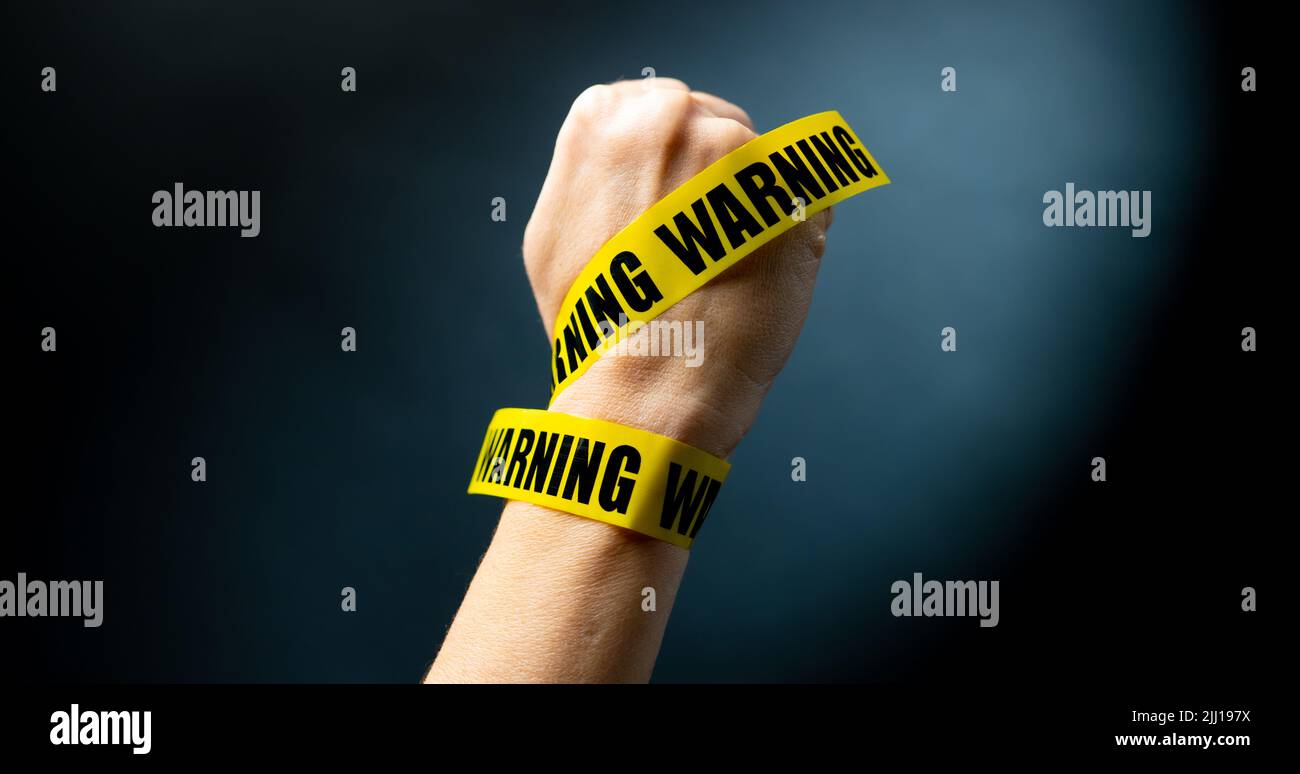 Hand with warning tape shows signs Stock Photo - Alamy