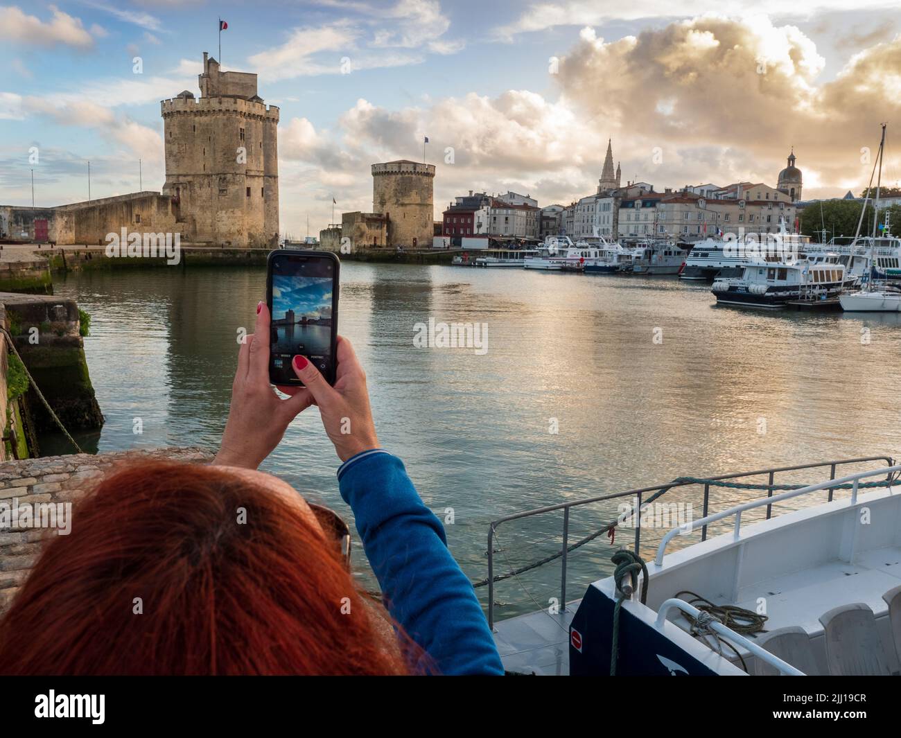 La Rochelle, France, July 2022. A tourist with a phone in her hand ...