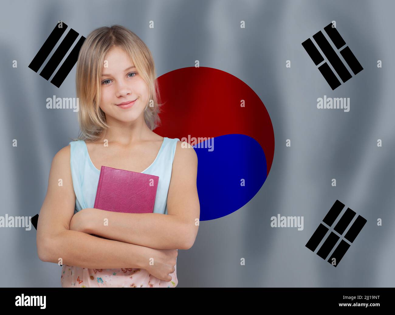 Smiling blonde teen girl student standing against flag of South Korea ...