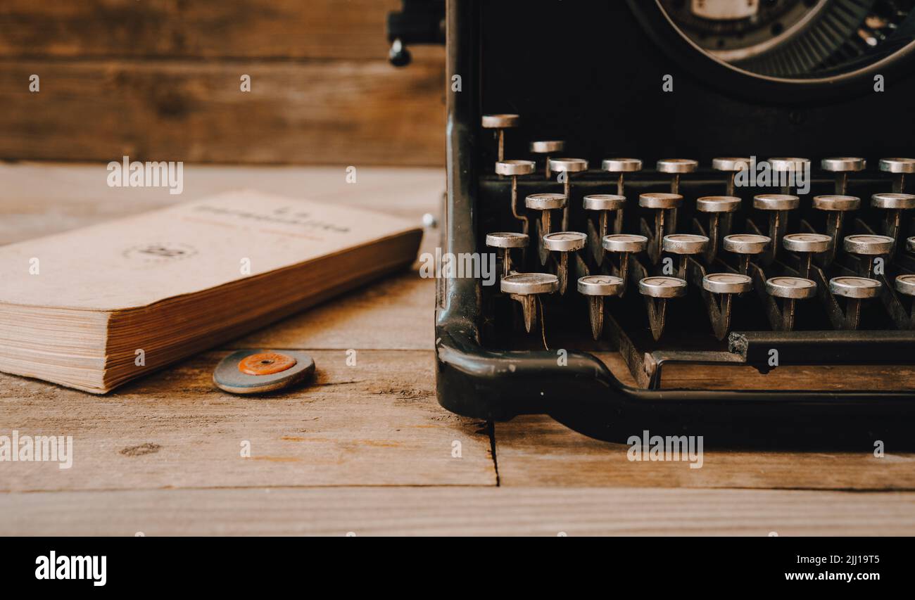A vintage typewriter with a rubber and an old book Stock Photo - Alamy