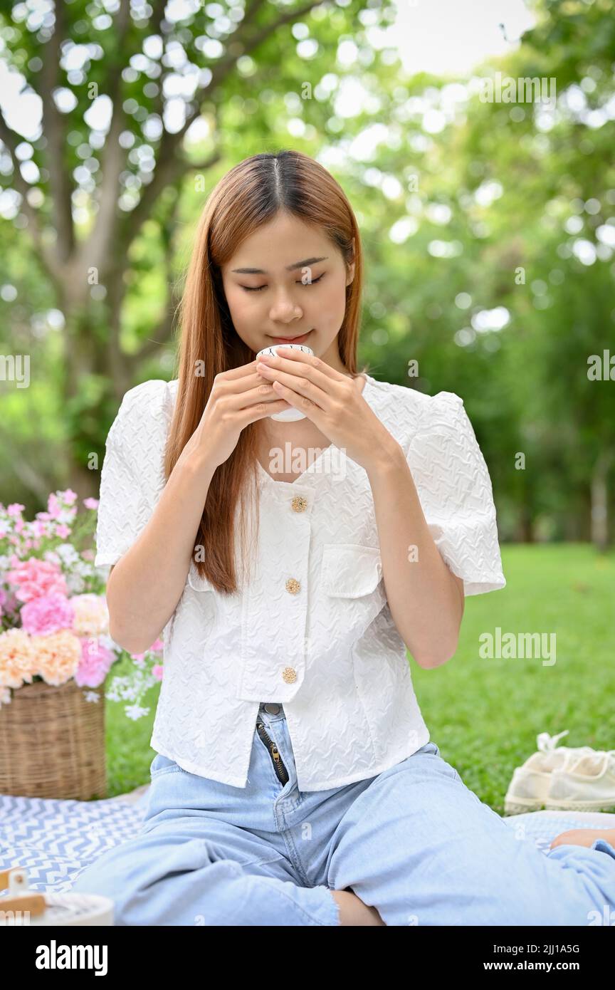 Portrait of a calm and relaxed young Asian female having an afternoon ...