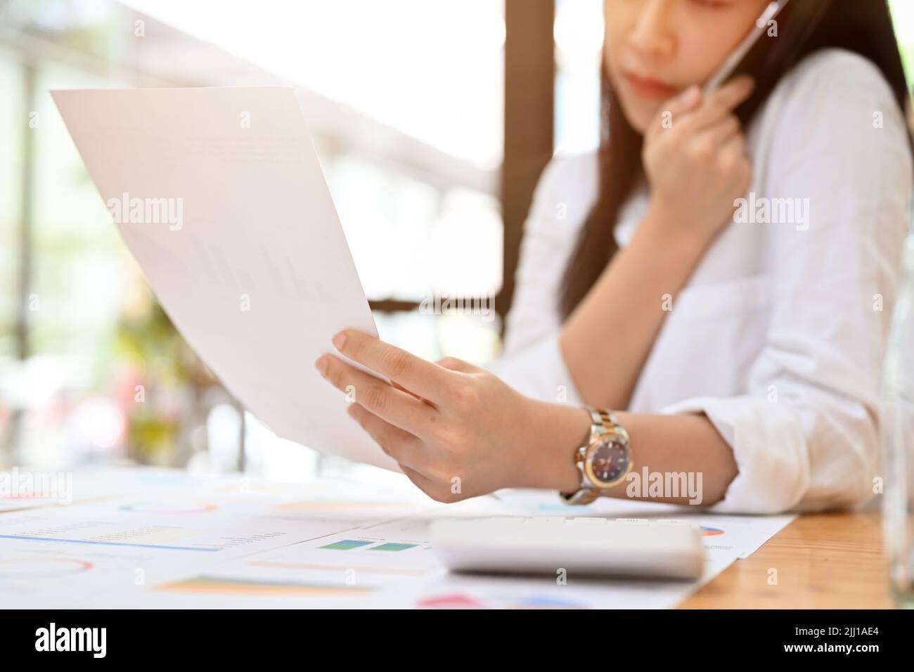 Busy adult Asian businesswoman or female marketing manager looking some ...