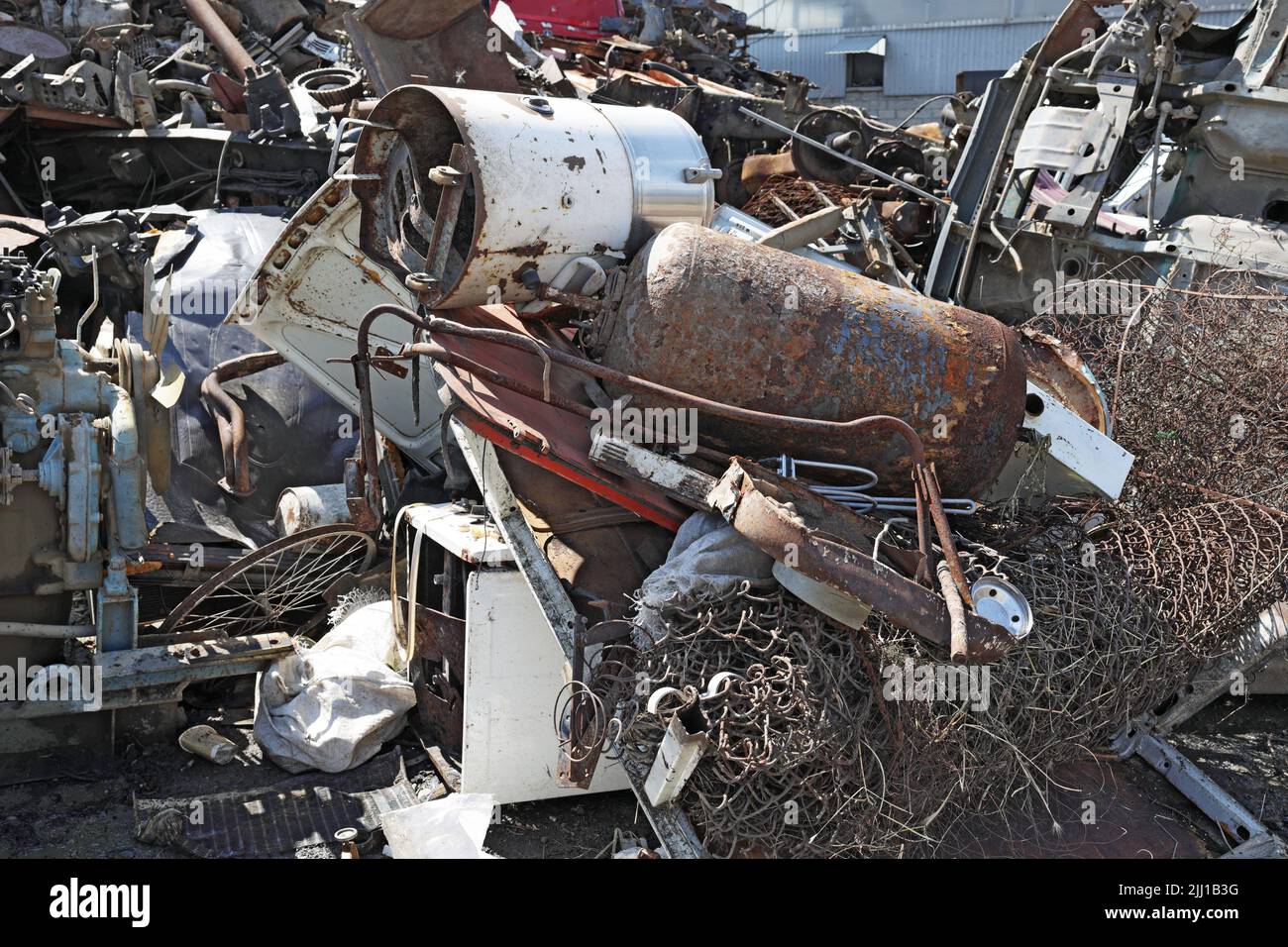 Scrap metal waste is stored in a recycling yard waiting to be melted ...