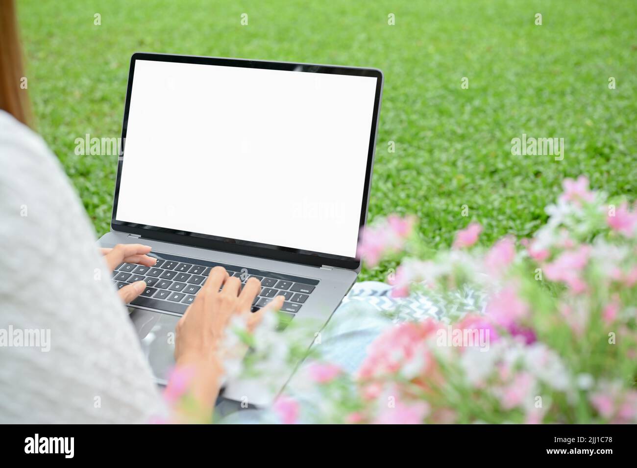 A young Asian female or college student sits under the tree in the park ...