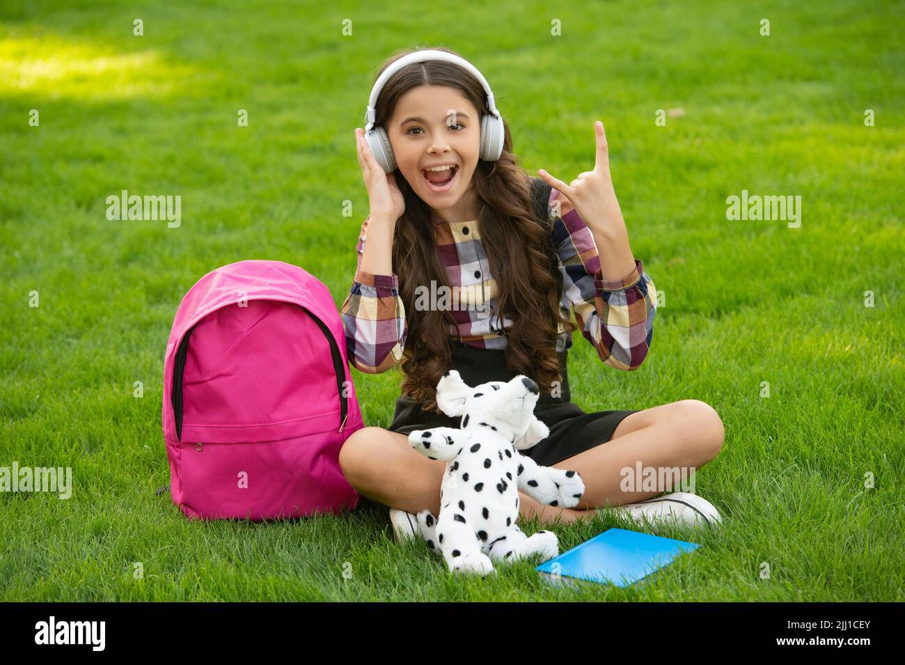 Happy teen girl showing horn sign after school, music. back to school ...