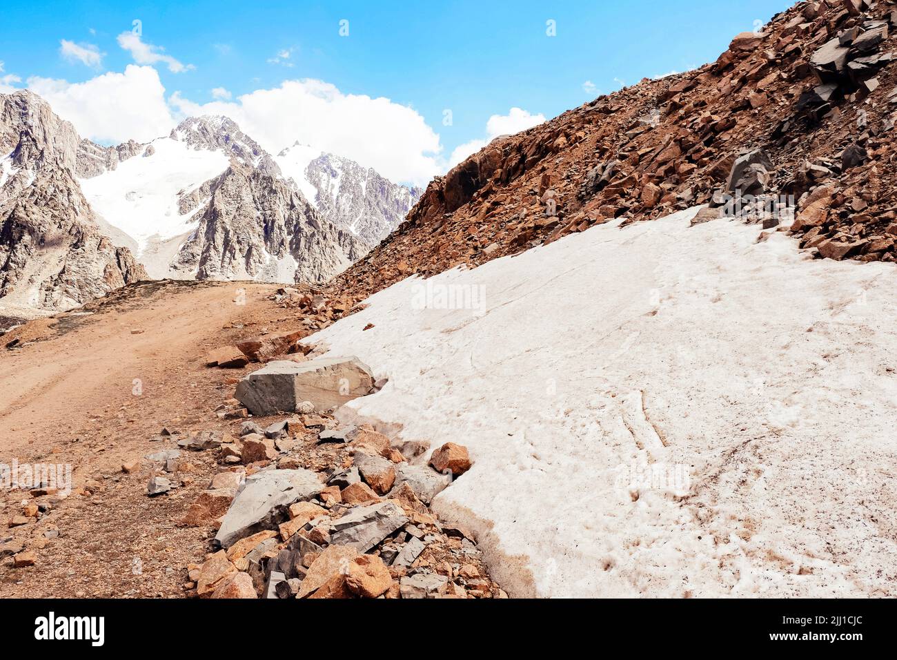 Beautiful mountain road with rocks and a slide of snow. Mountains on ...