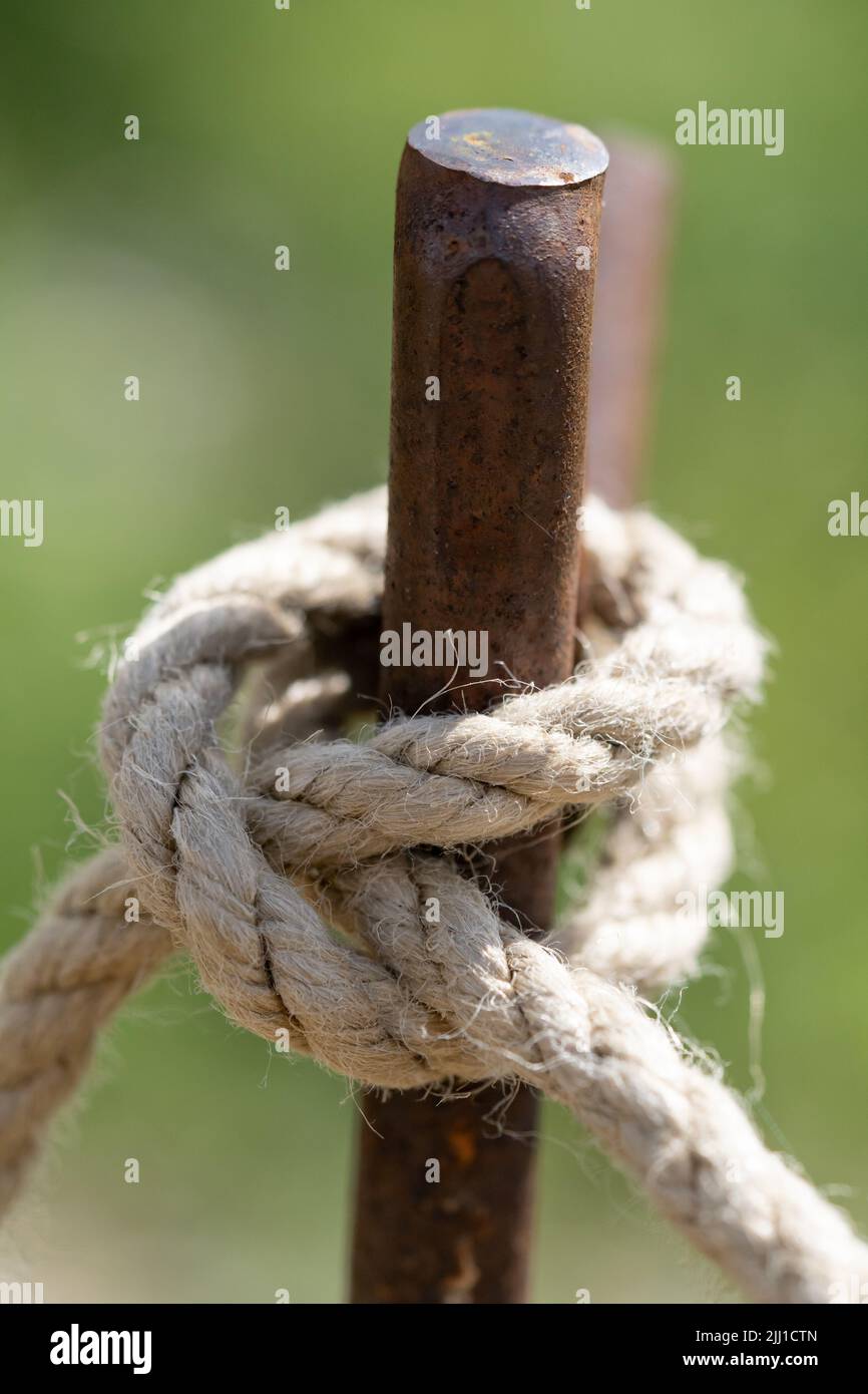 A rope knot tied to a metal pole on a blurred background Stock Photo ...