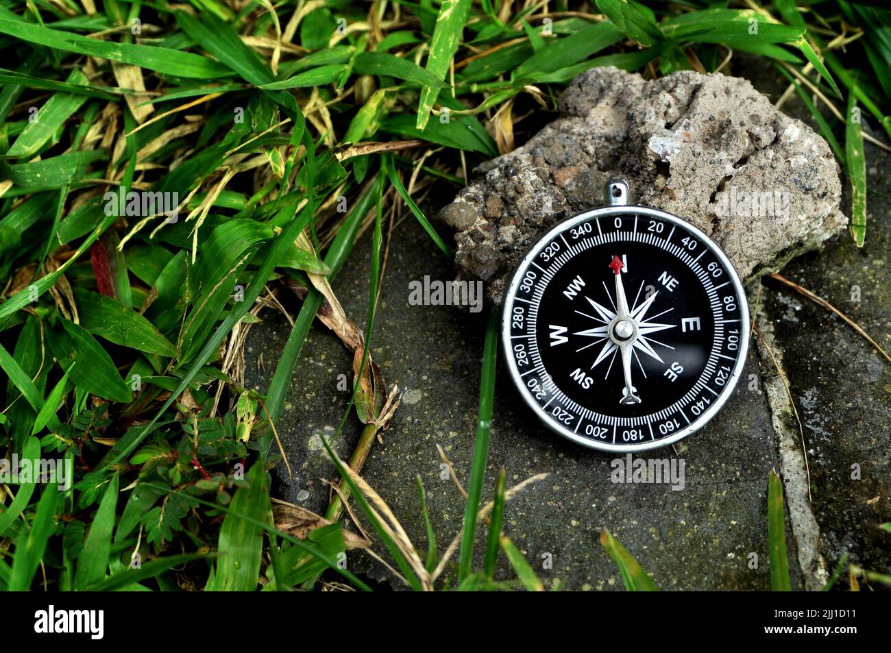 Navigation compass in ground with green grass Stock Photo - Alamy