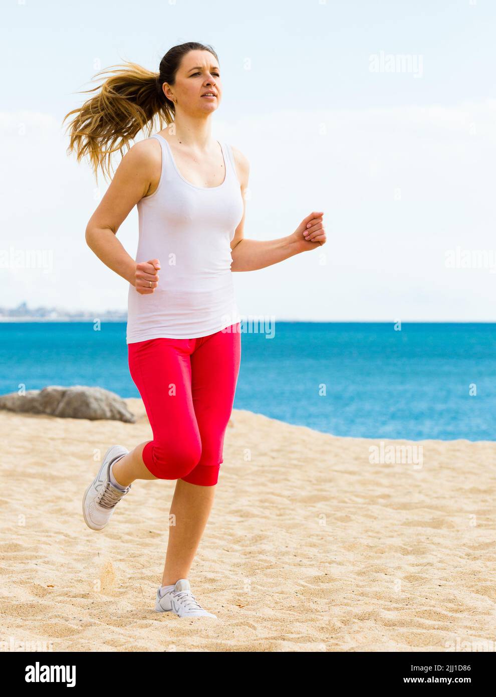 Woman running on beach Stock Photo - Alamy