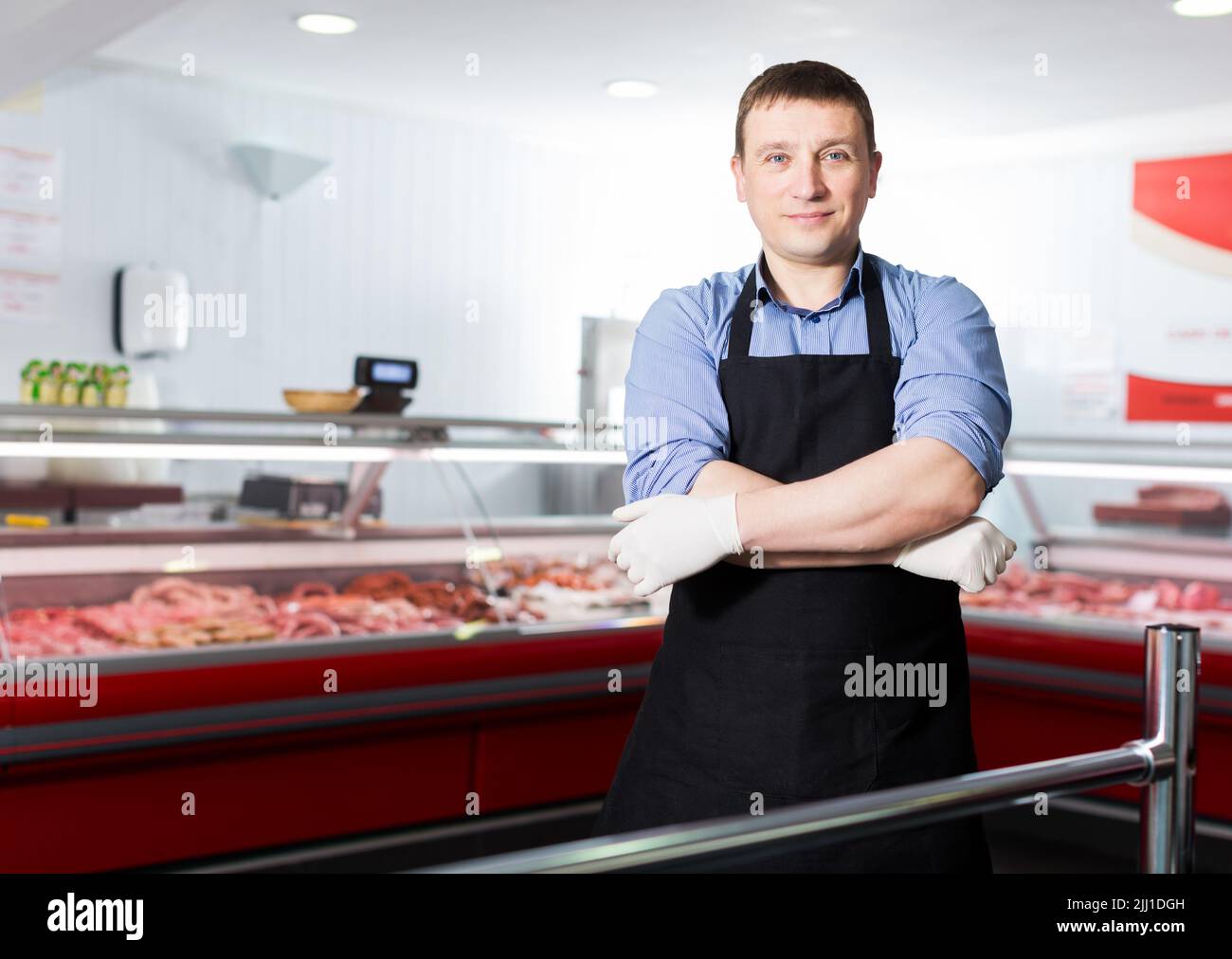 owner of butcher shop standing with arms crossed Stock Photo - Alamy