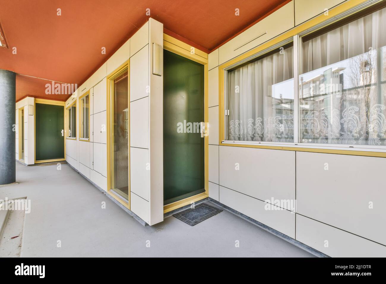 The front view of a brick building with signs,pavement and wooden doors ...