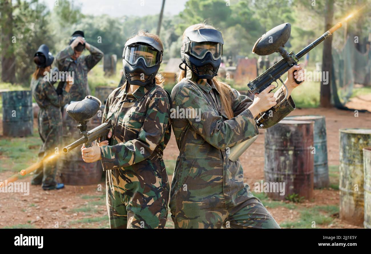 Portrait of confident female paintball players with marker guns Stock ...