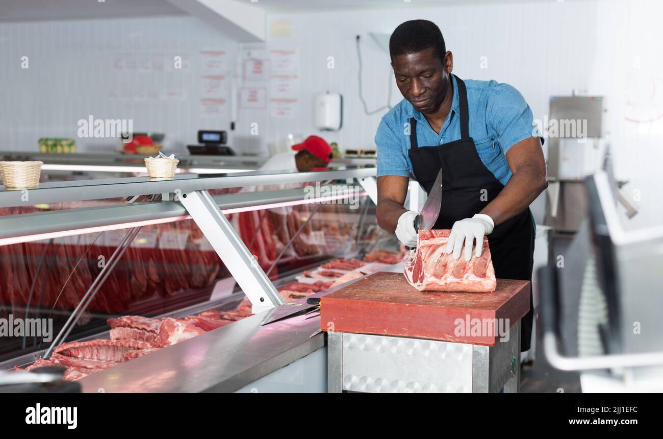 Butcher cutting meat Stock Photo - Alamy