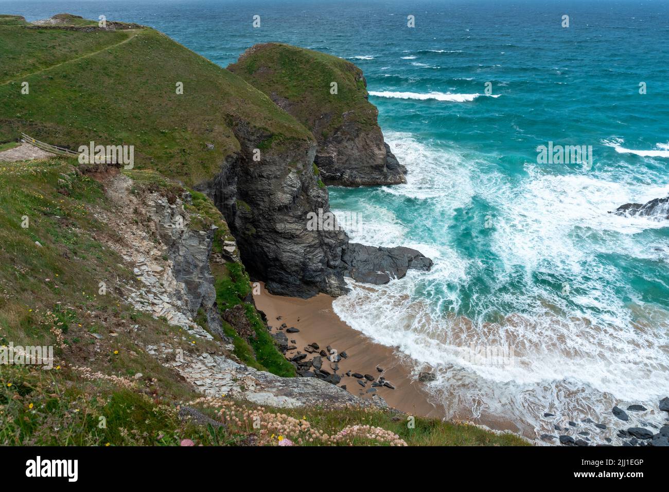 looking down at Pentire Steps Beach and the big waves and rocks Stock ...
