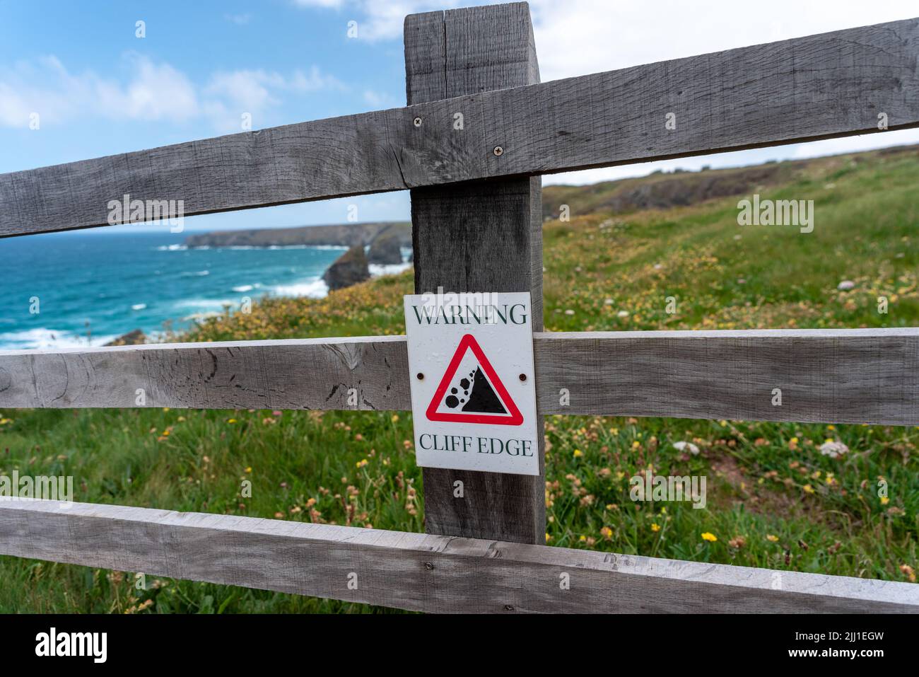 warning cliff signs on a wooden fence with green background Stock Photo ...