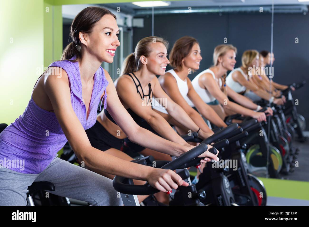 Girls during workout on stationary bicycle in fitness gym Stock Photo ...