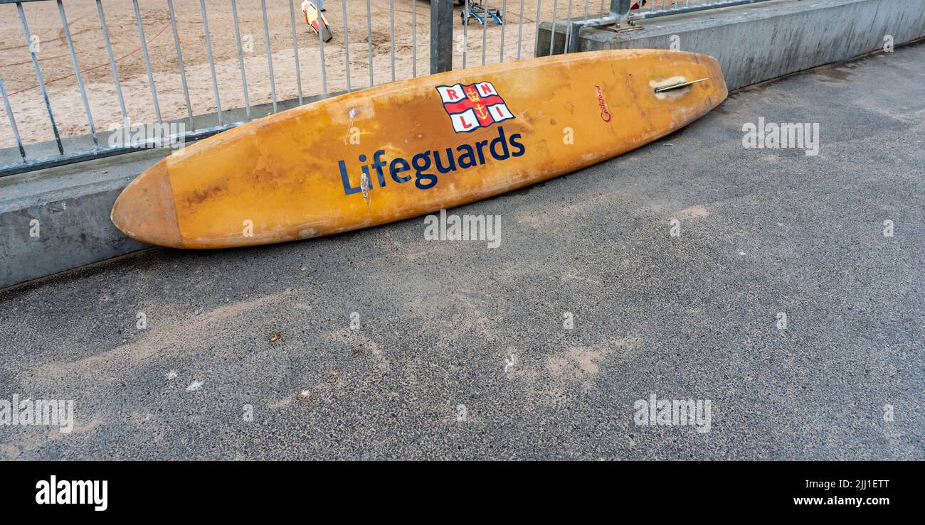 A lifeguard surfboard propped up against the wall ready to go , Fistral ...