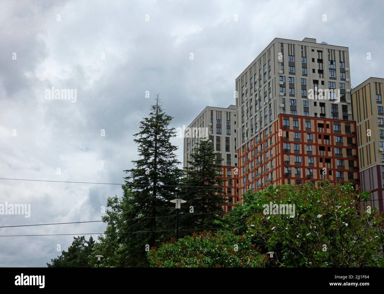 New modern block of flats in green area with blue sky. Cityscape ...
