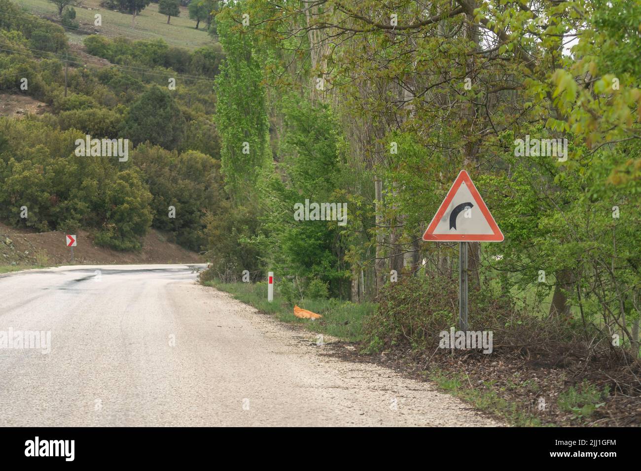 Selective focus shot of a road through nature and a traffic sign ...