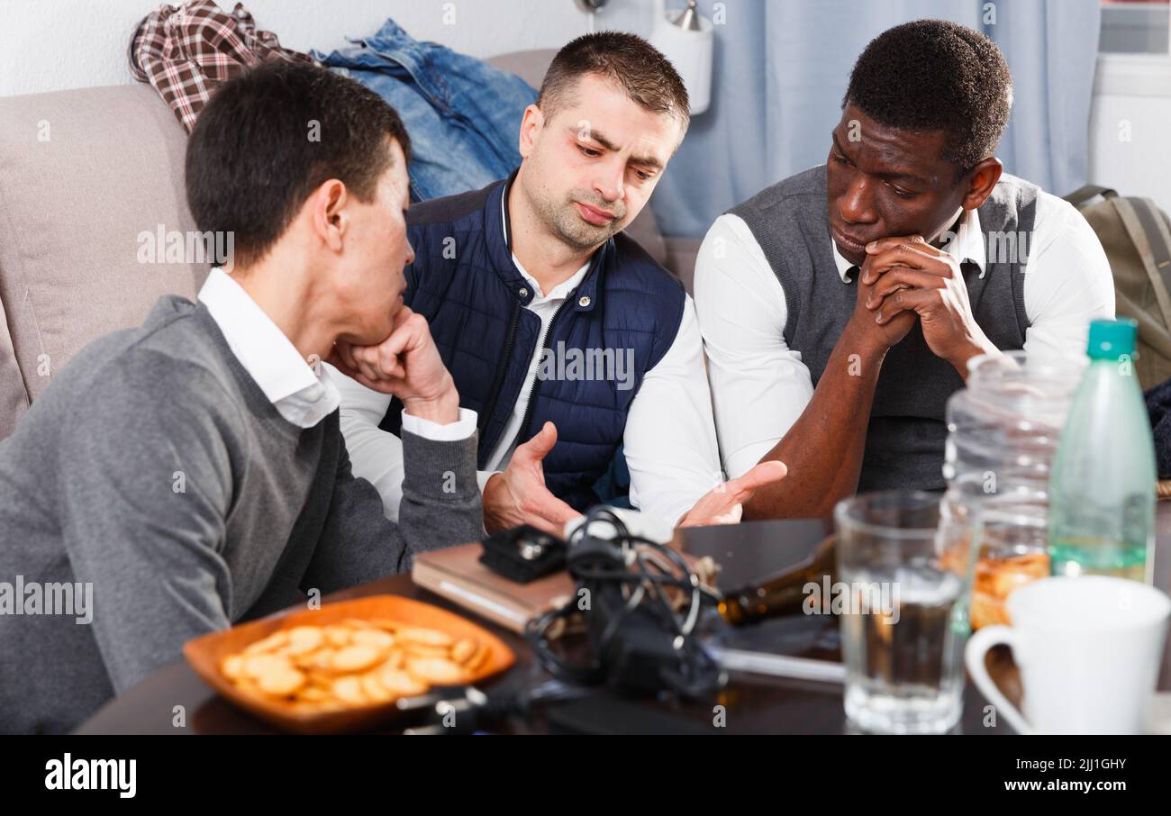 Three serious friends are talking about life together Stock Photo - Alamy