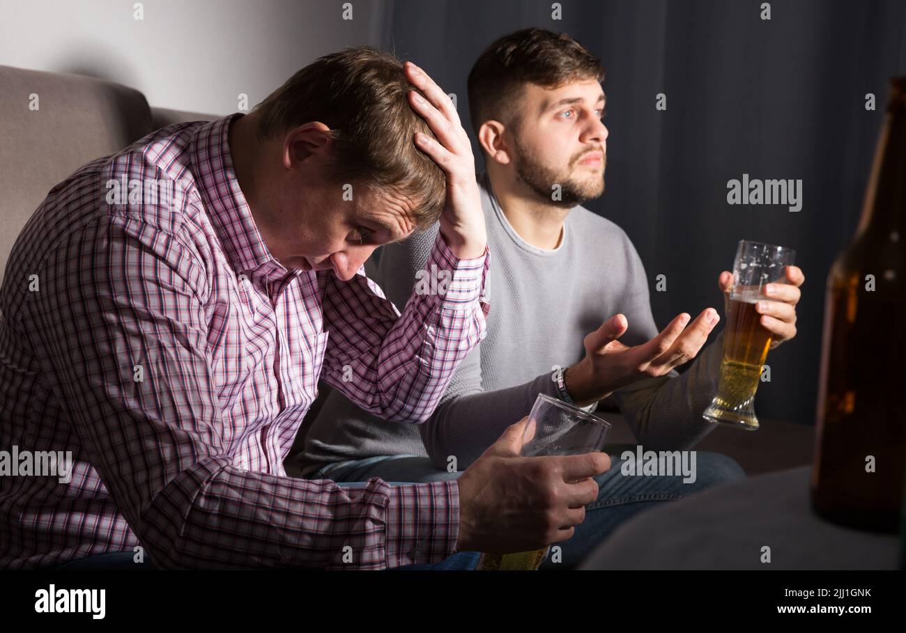 Frustrated men watching matchup on tv Stock Photo - Alamy
