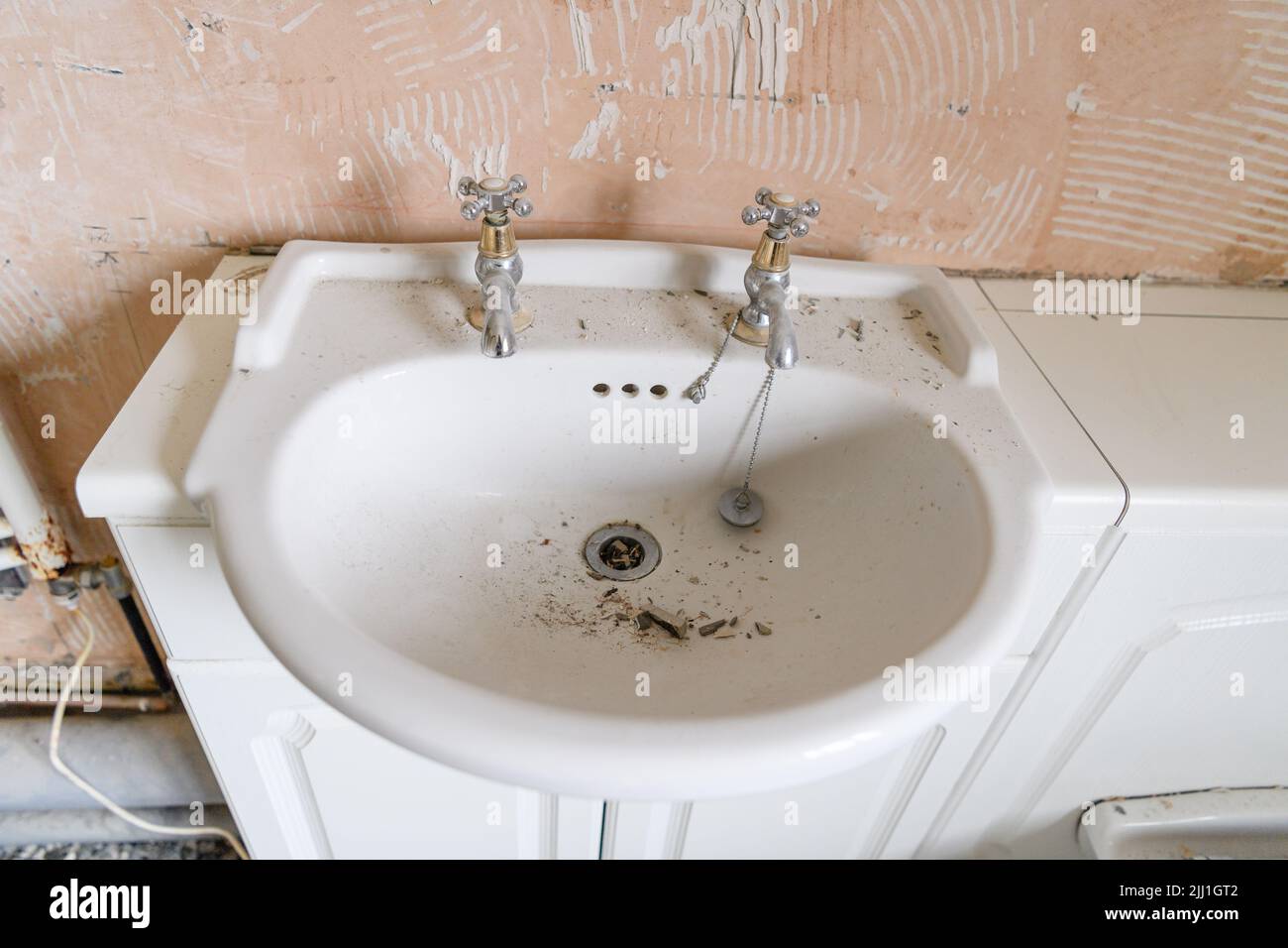 A dirty bathroom sink against an old wall during renovation Stock Photo ...