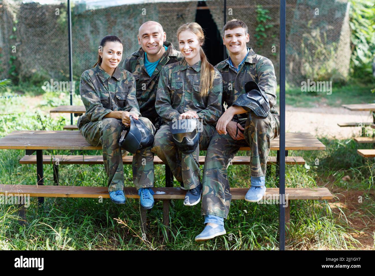 Portrait of paintball players wearing uniform and holding guns ready ...