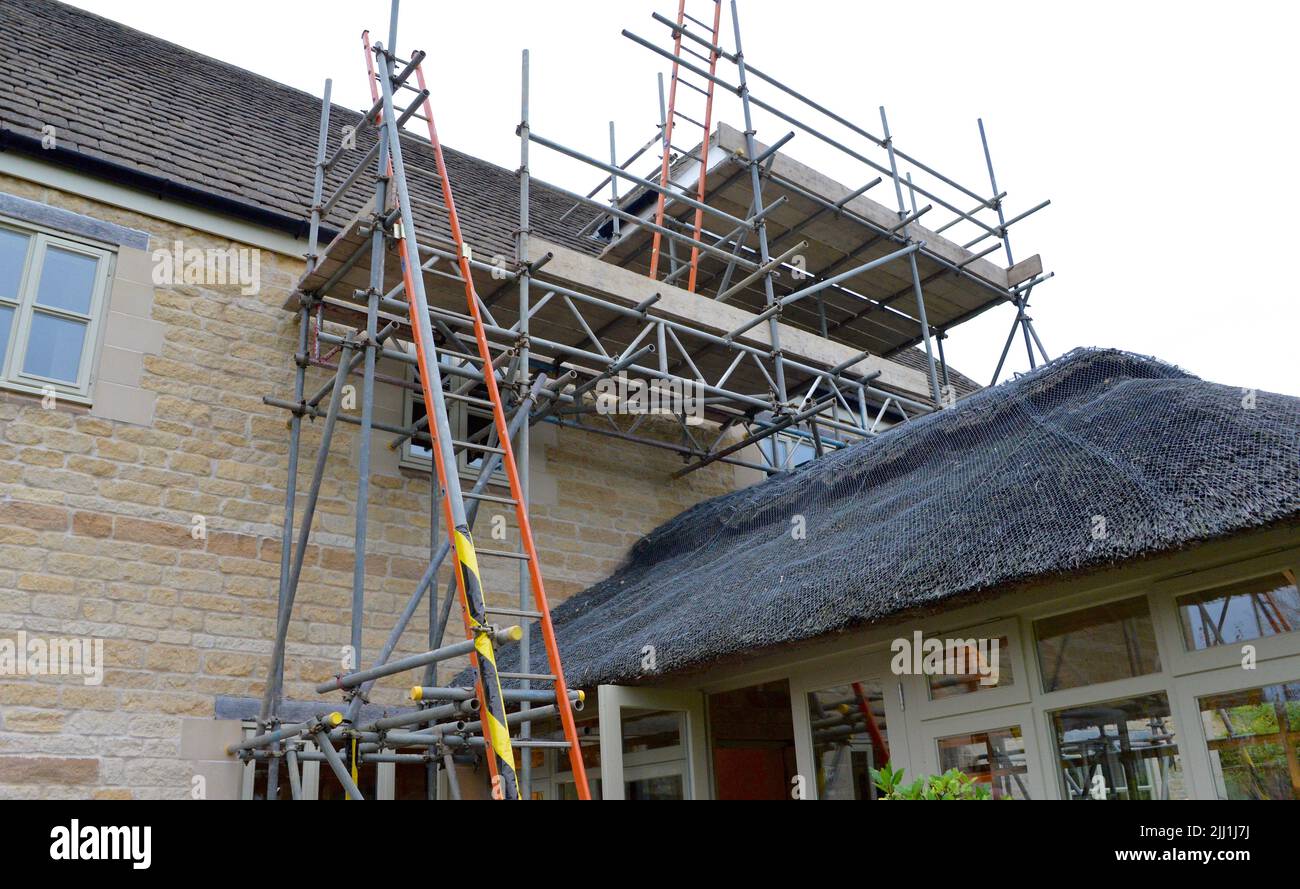 A low angle shot of ladder and scaffold leaning on brick building for ...