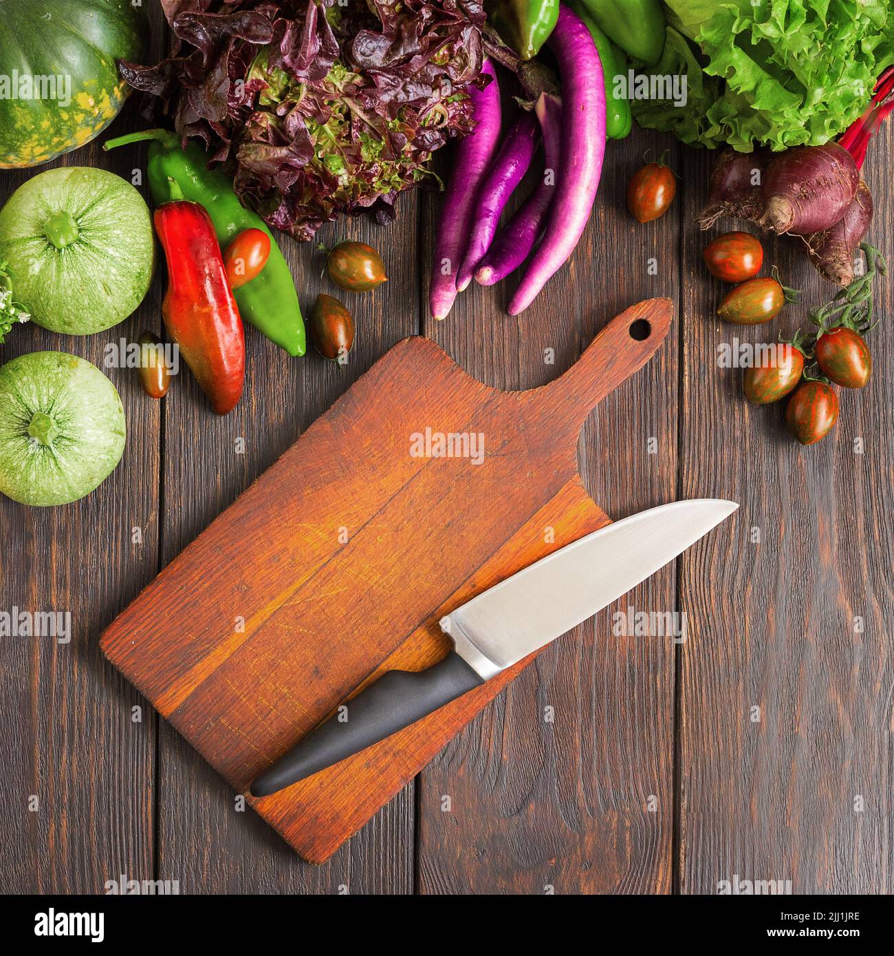Different vegetables and empty cutting board with chef kitchen knife ...